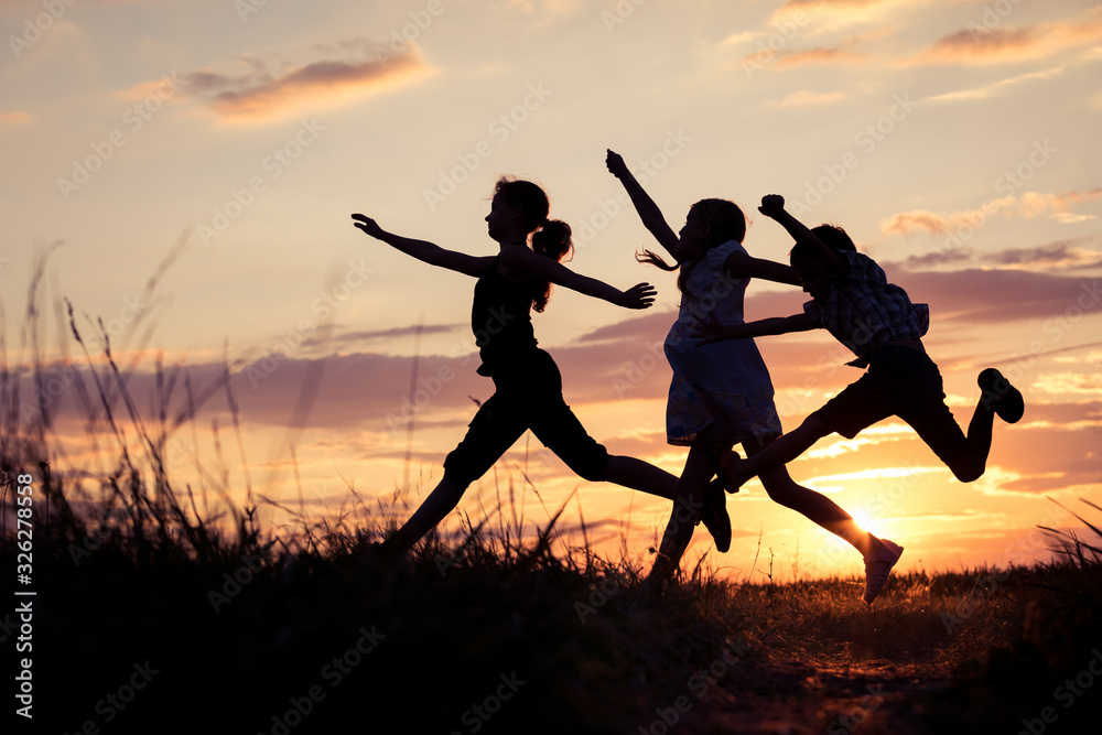 Happy children playing in the park at the sunset time. Stock Photo ...