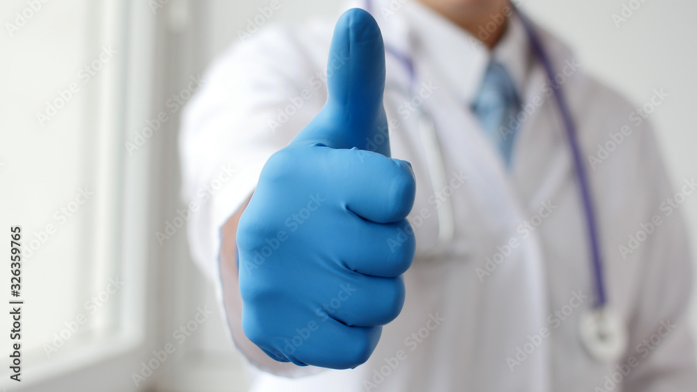 Thumbs up symbol by smiling young confident doctor. Health care concept ...