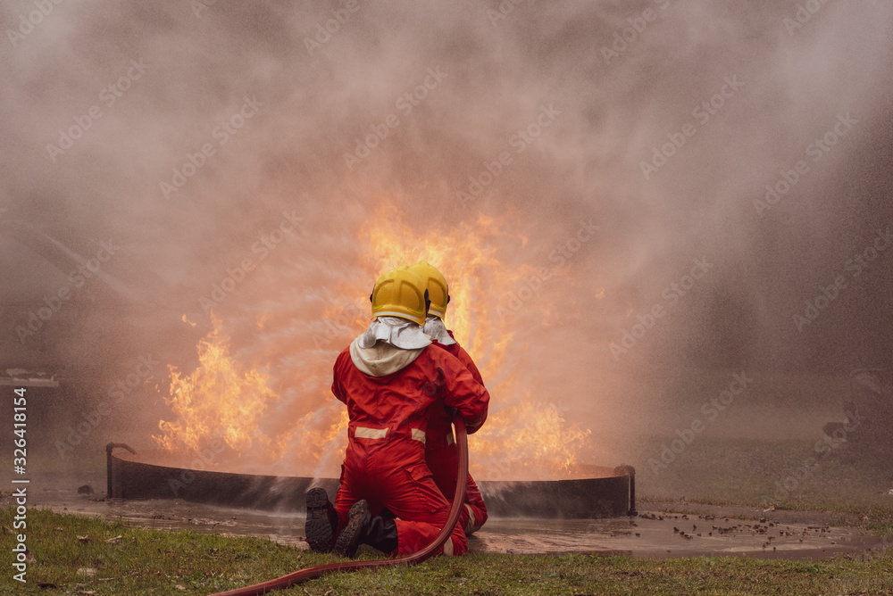 Two brave firefighter using extinguisher and water from hose for fire ...