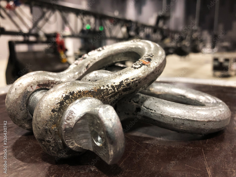 Steel rigging shackles on flight case. Metal truss with light and sound ...