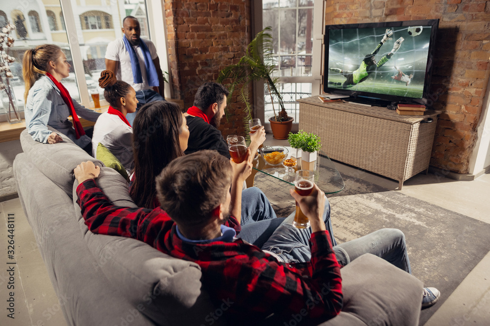 Excited group of people watching football, soccer sport match at home ...