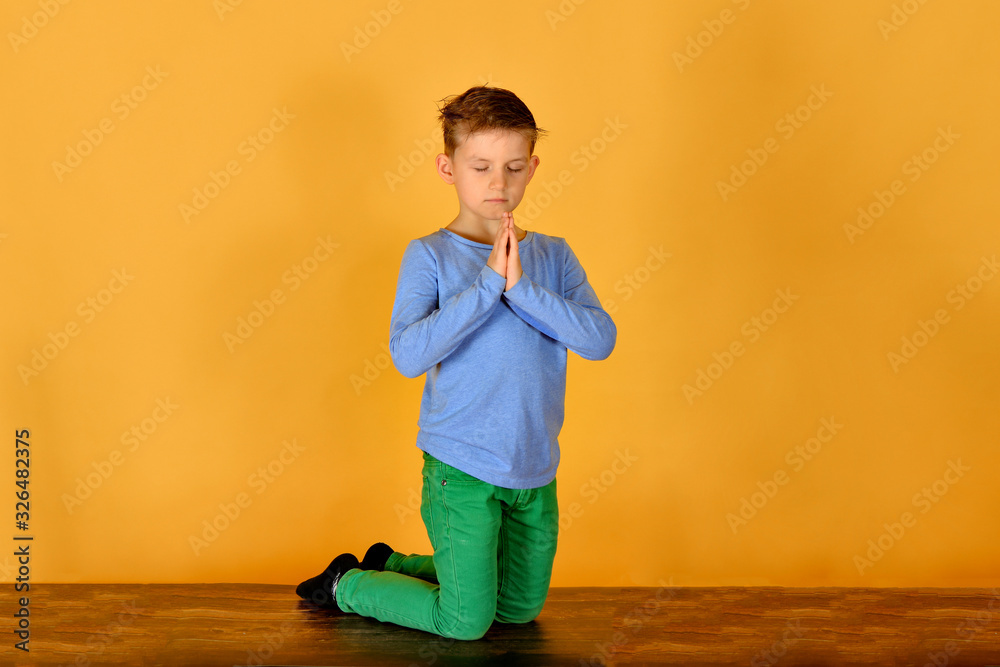 A boy prays kneeling, religious and devout children. Stock Photo ...