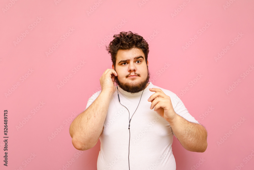 Portrait of a funny fat man with curly hair and headphones isolated on ...