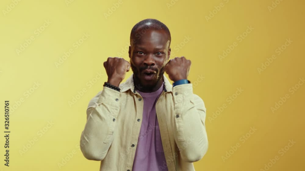 Uncertain black young man crosses fingers for good luck waiting at ...