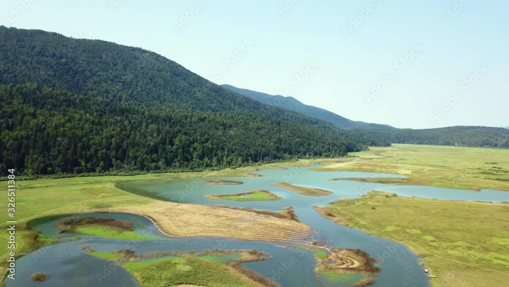 Vidéo Stock AERIAL: Curved lake with beautiful mountain tree forest in ...