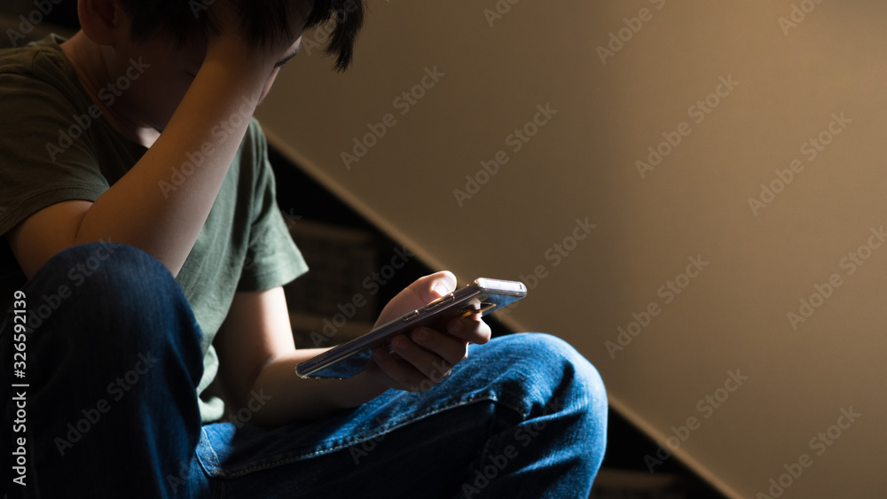 Young Asian preteen/teenage boy sit on stair at home, cry and cover his ...