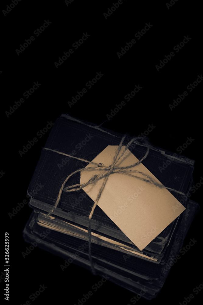Antique old books stacked into a pile tied with string with a label ...