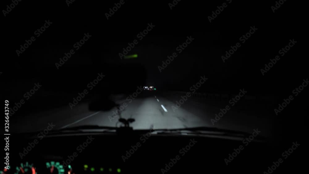 The driver rides at night on a lighted road. The car cracks and ...