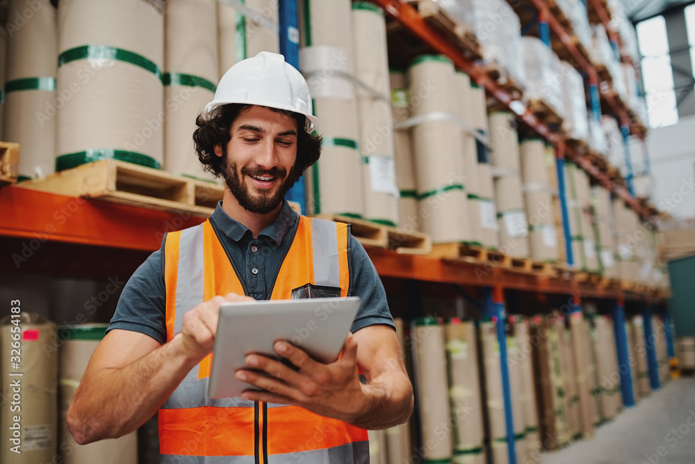 Male warehouse manager adding stock inventory data in digital tablet in ...