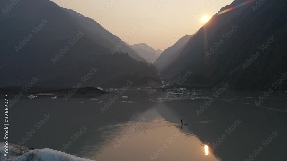Close up drone shot over an iceberg with a paddle boarding moving from ...