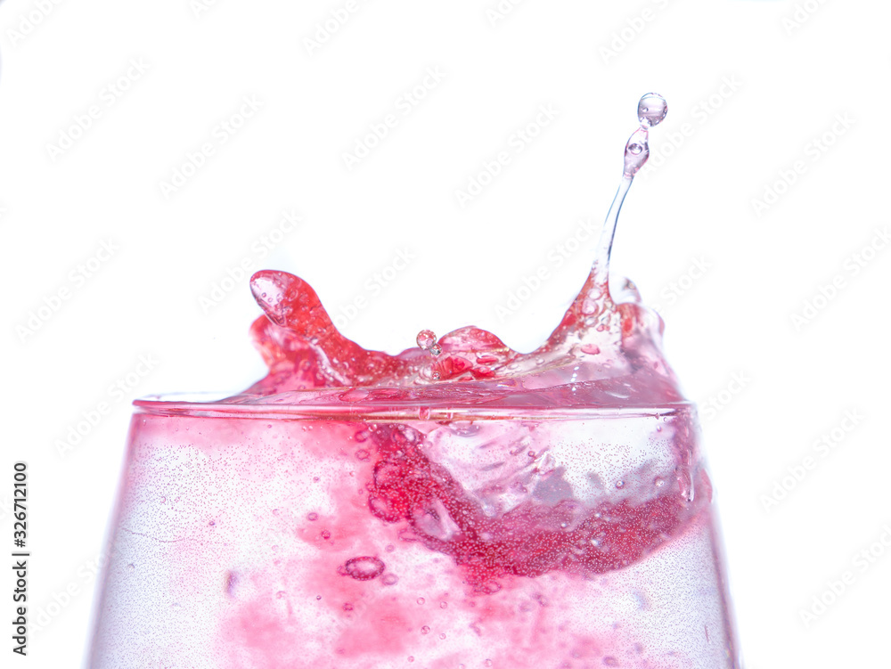 pink liquid being dropped on a glass, isolated on white background ...