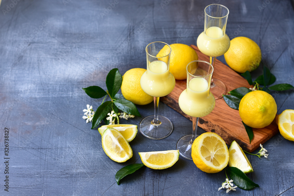 traditional Italian digestif liqueur Limoncello with lemons and cream ...
