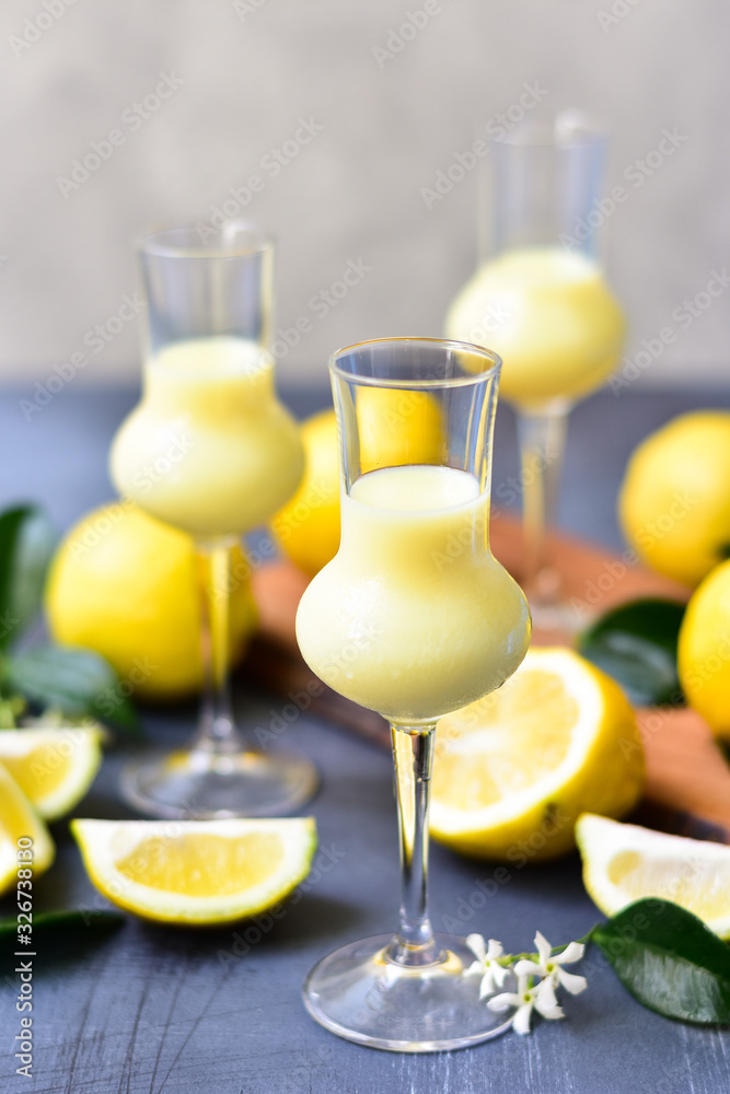 traditional Italian digestif liqueur Limoncello with lemons and cream ...