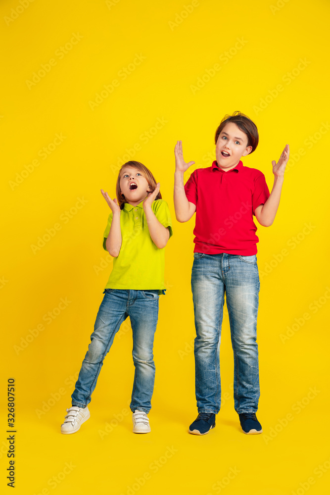 Astonished. Happy children playing and having fun together on yellow ...