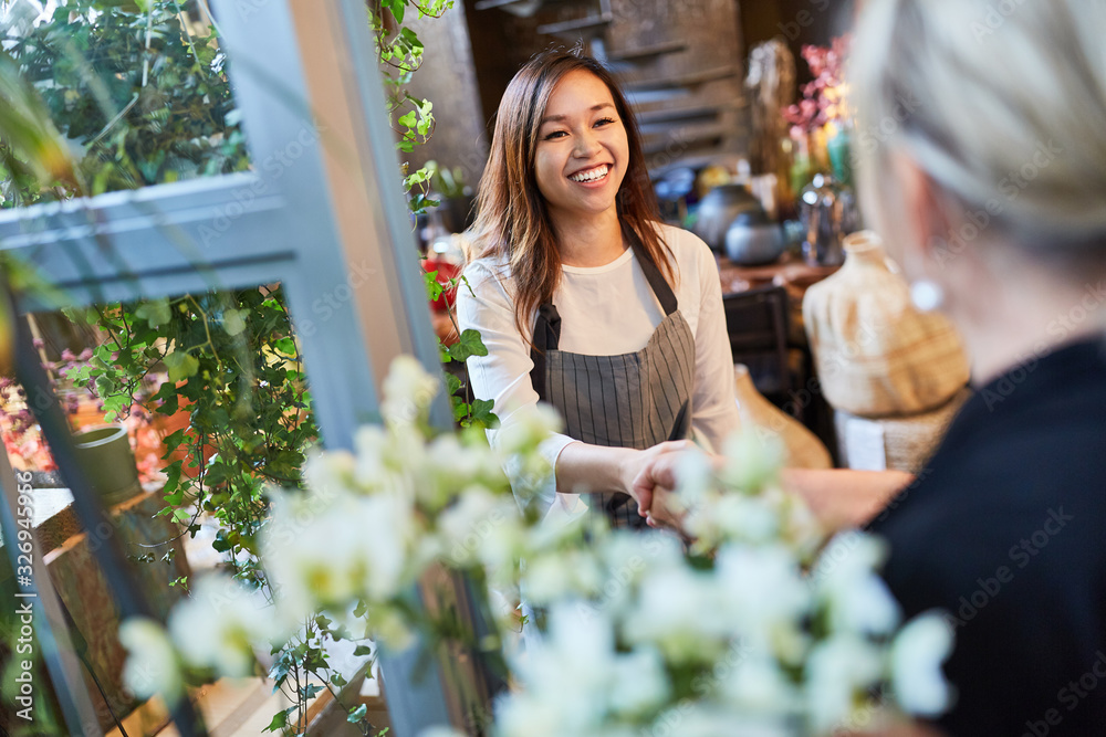 Florist welcomes customer with handshake in flower shop Stock Photo ...