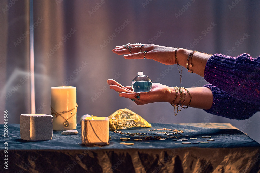 Witch female with elixir potion bottle around candles and magical ...