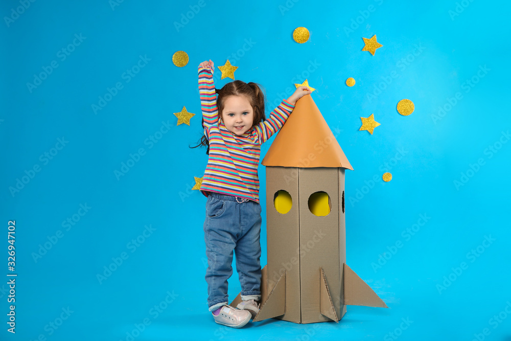 Little child playing with rocket made of cardboard box near stars on ...