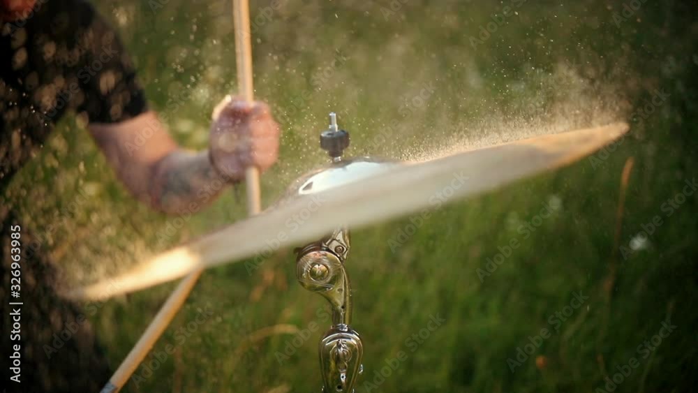 man musician drummer hitting on wet drum cymbal, and the water ...