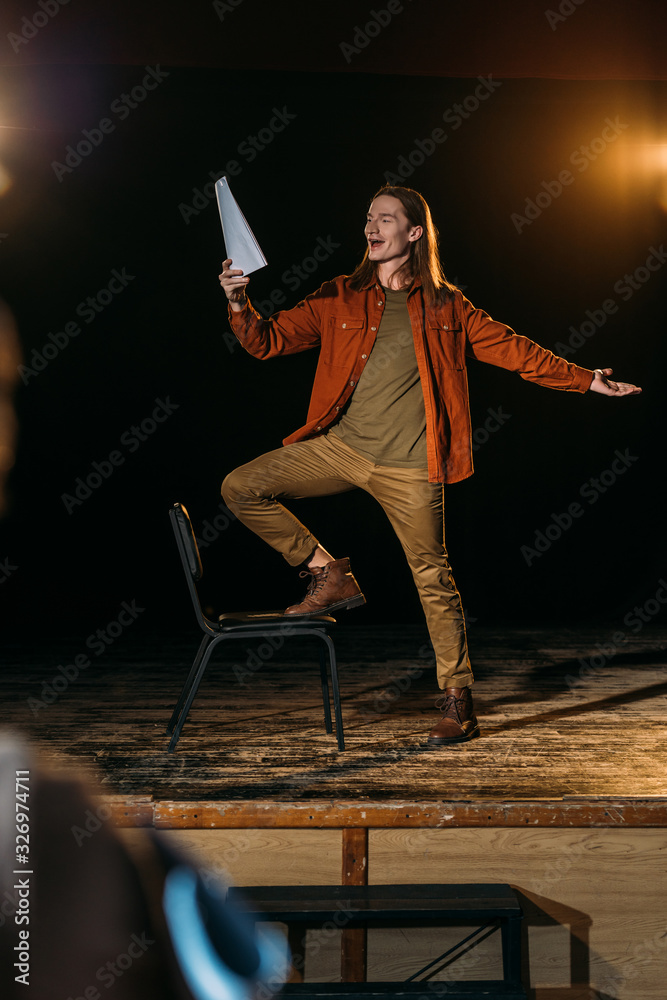 handsome actor with screenplay playing on stage during rehearse in ...