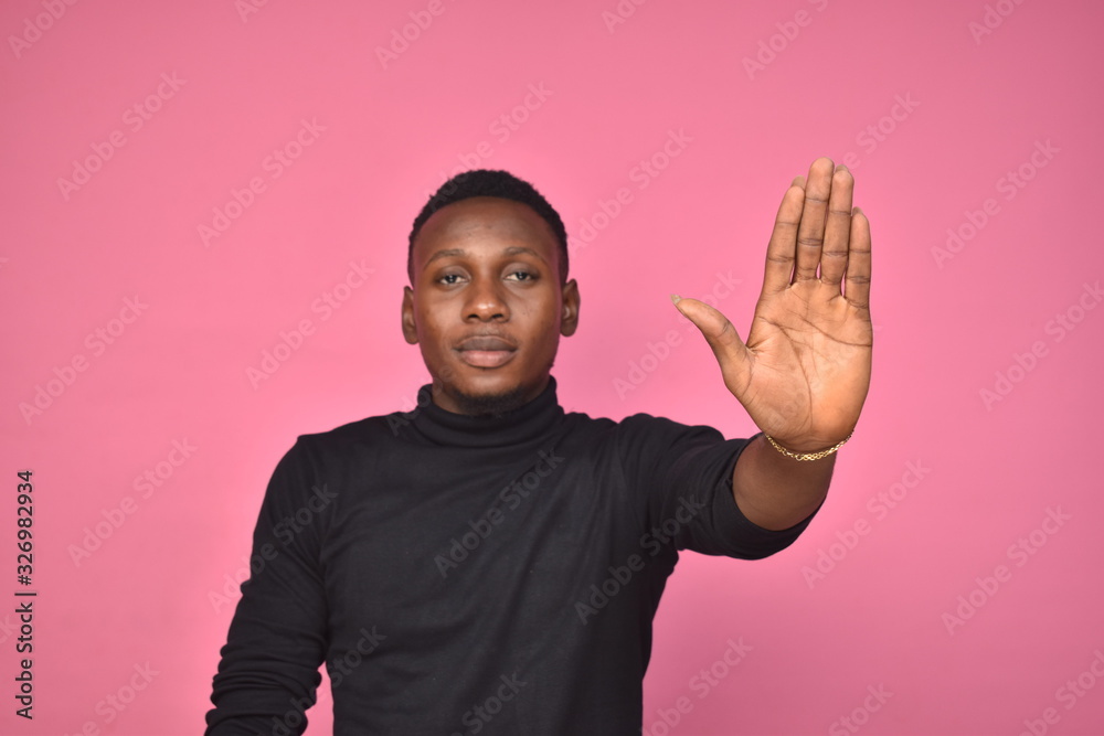 young black man making a stop sign with his hand towards the viewers ...