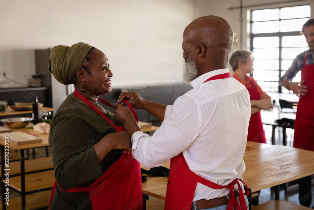 African man helping an African woman to put on her apron Stock Photo ...
