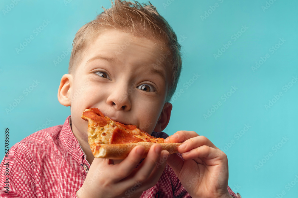little boy eats a slice of pepperoni pizza. kids love pizza Stock Photo ...