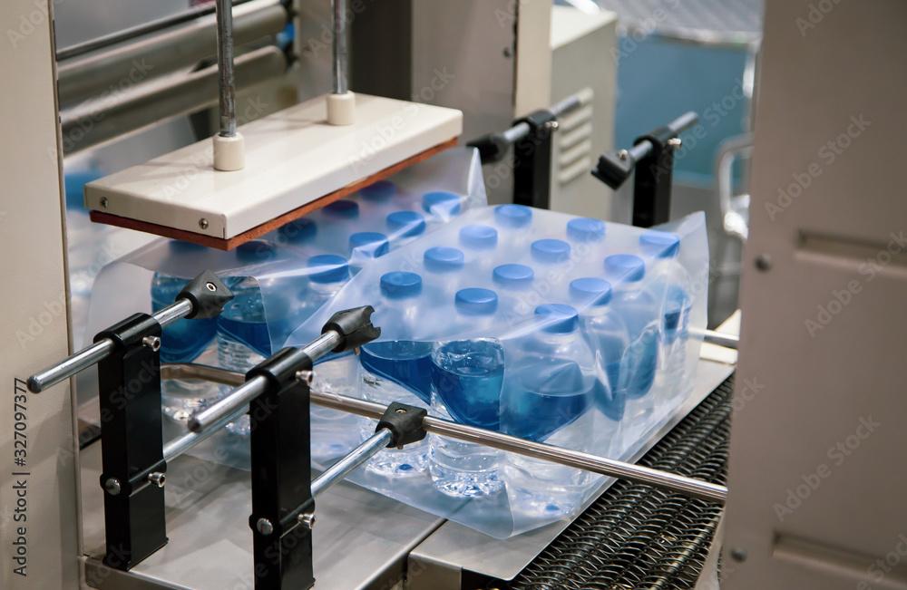 Shrink film wrapping machine for bottle of water Stock Photo | Adobe Stock