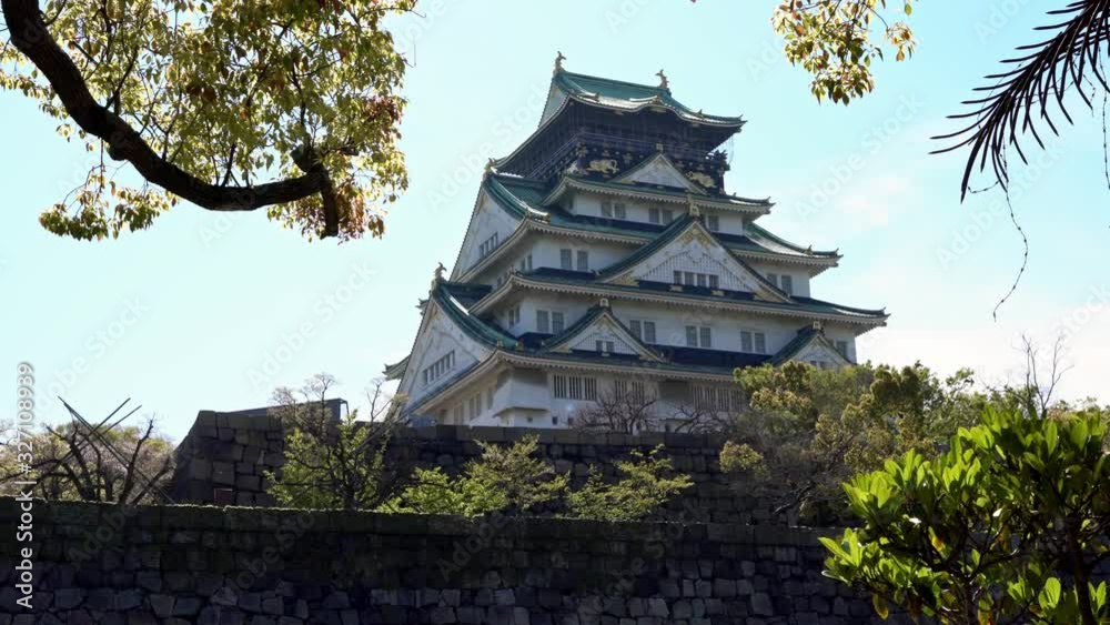 4K, Main tower of Osaka Japanese Castle behind rock wall, famous ...