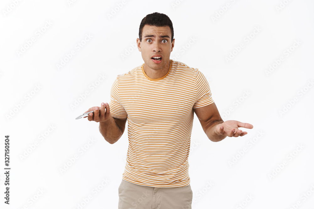 Confused and worried young man dont know what did wrong, shrugging and ...