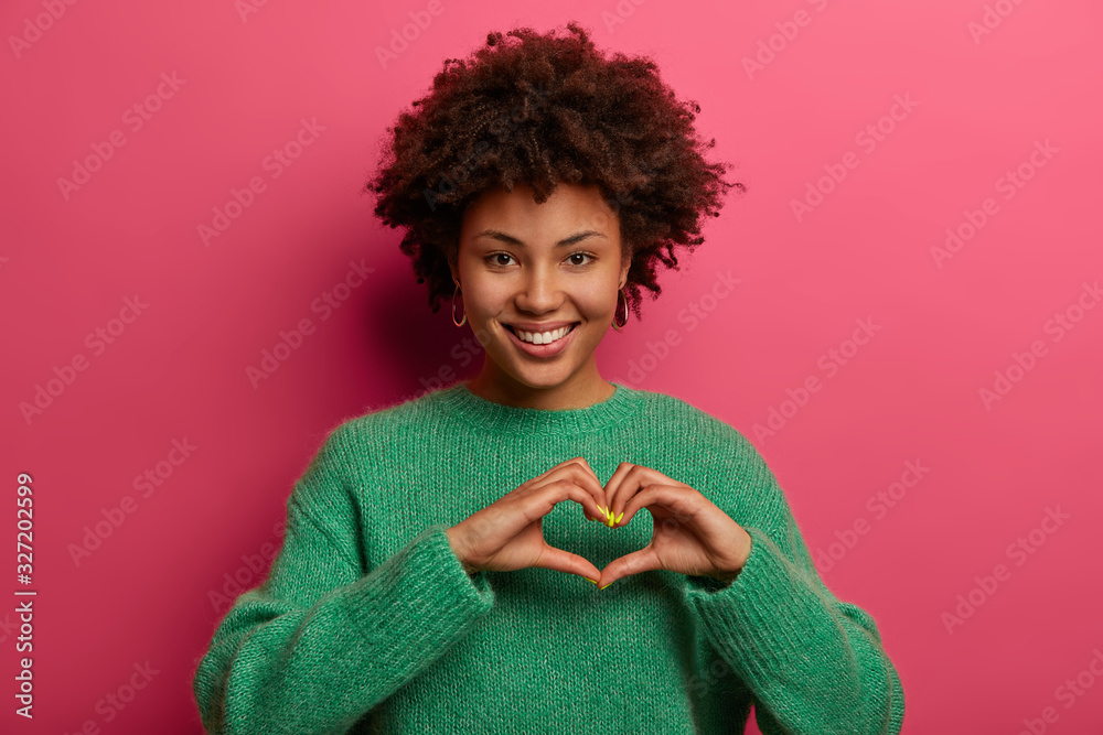 Pretty charming woman shapes heart gesture, shows what boyfriend mean ...