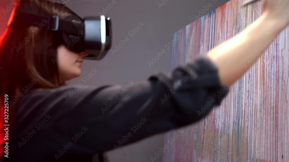 Talented female artist wearing new virtual reality glasses, using two ...