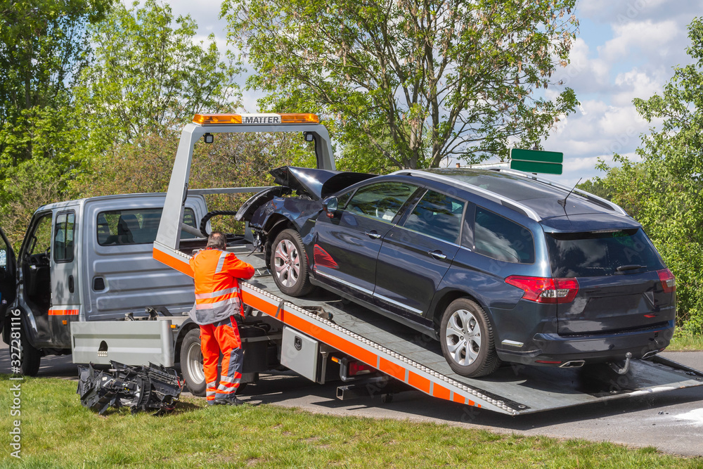 ein Unfallauto wird nach einem Unfall auf einen Abschlepper geladen ...