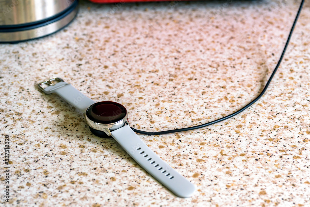 smart watch wireless charging on charging pad on kitchen worktop table ...