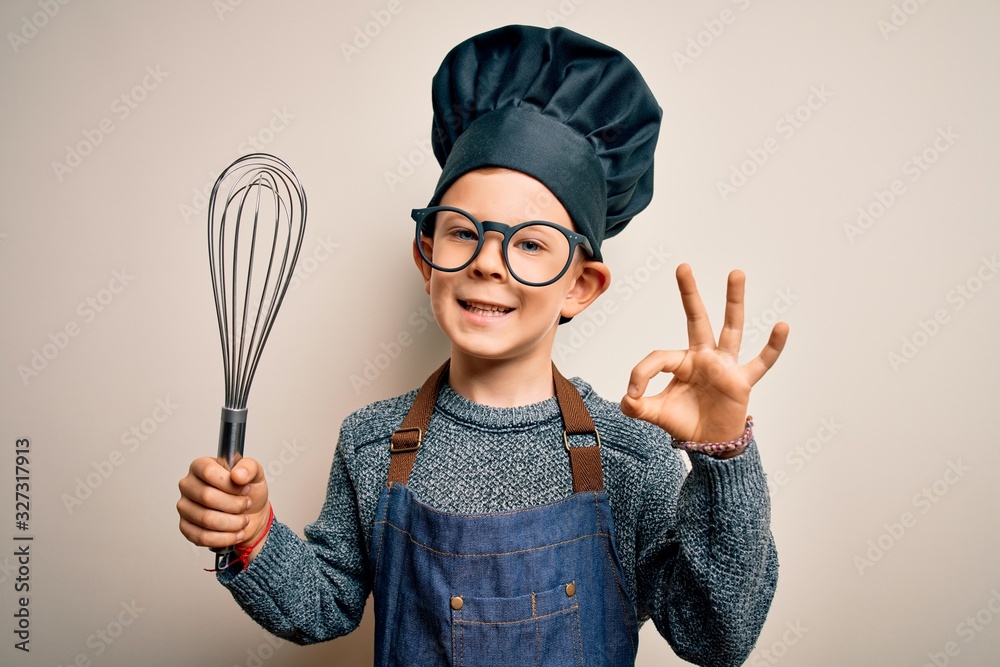 Young little caucasian cook kid wearing chef uniform and hat using ...