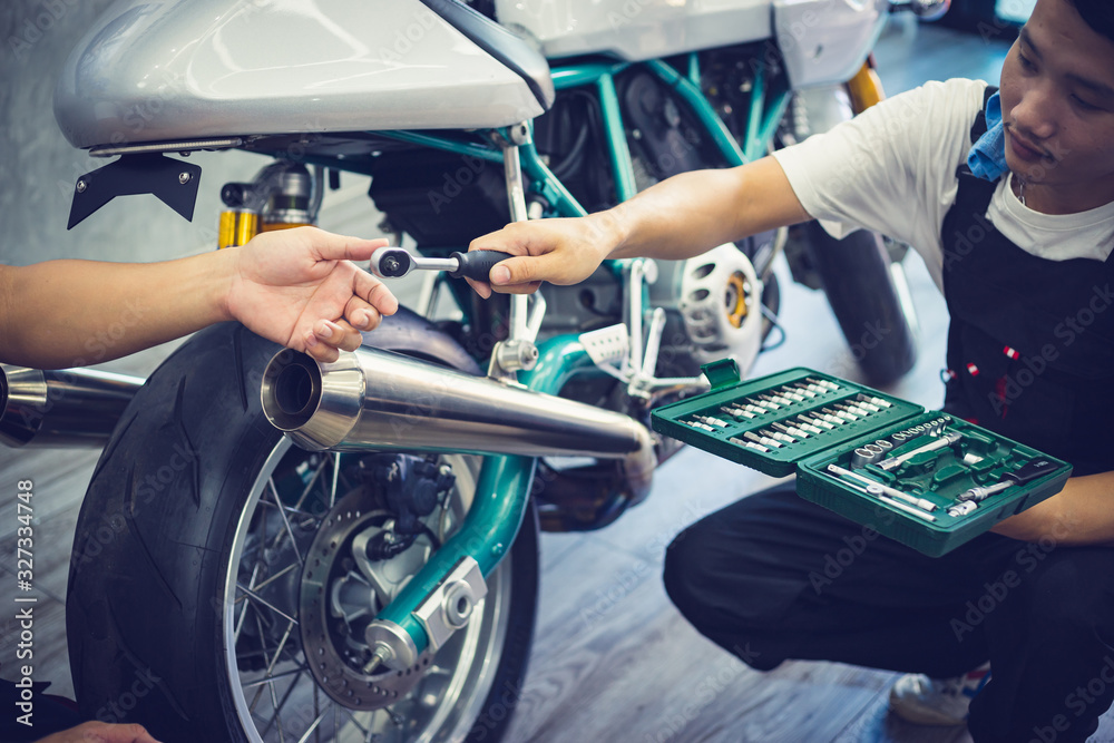 Asian mechanic man fixing the retro motorcycle in the garage. Film ...