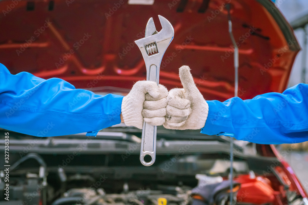 Mechanics holding wrench and tagging his friend's hannd. Team work ...