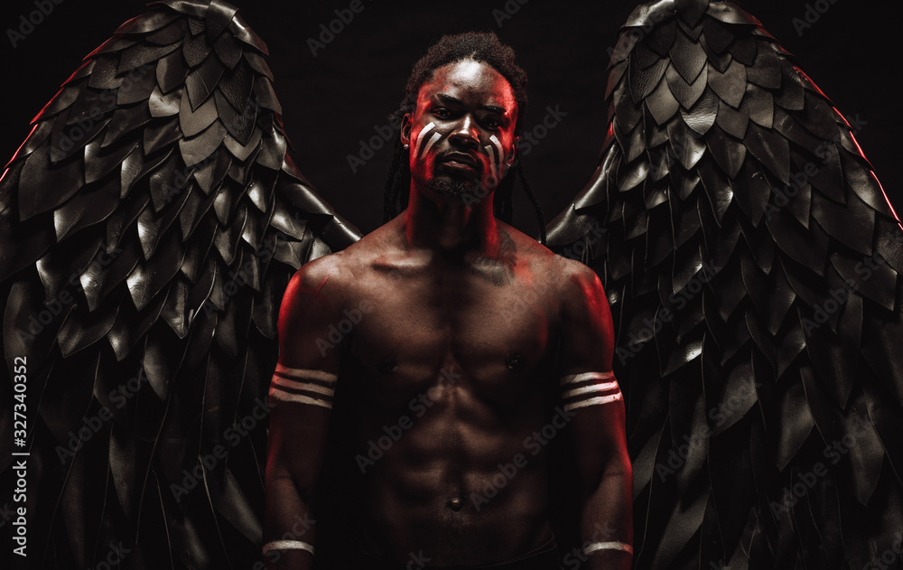 strong muscular angel with black wings fall on the earth, extraordinary ...