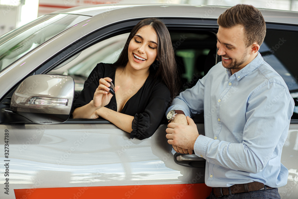 portrait of young caucasian married couple looking for a new car ...