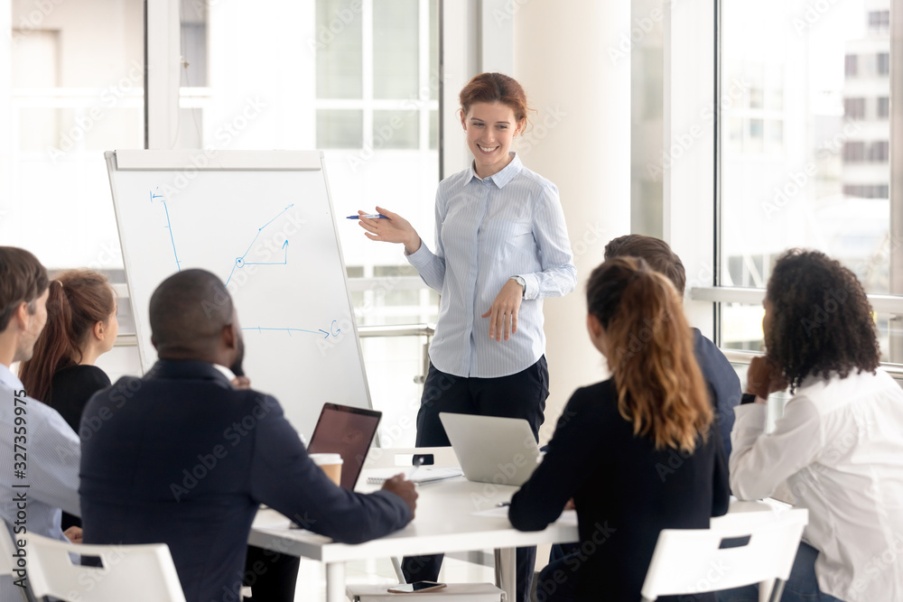 Smiling female employee with flip chart at presentation. Stock Photo ...