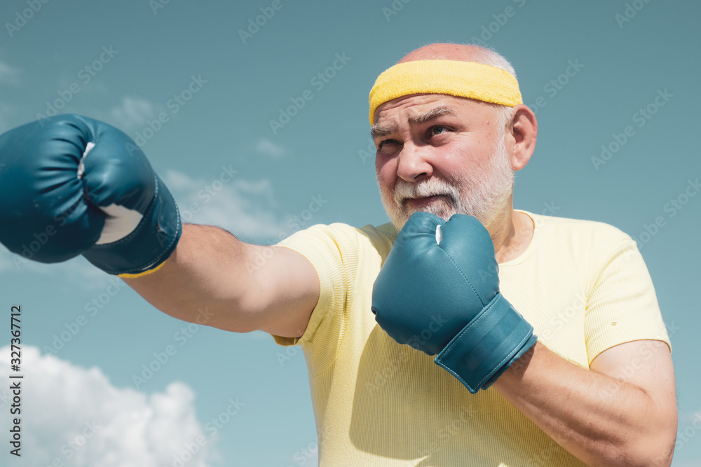 Handsome elderly man practicing boxing kicks. Elderly man hitting ...