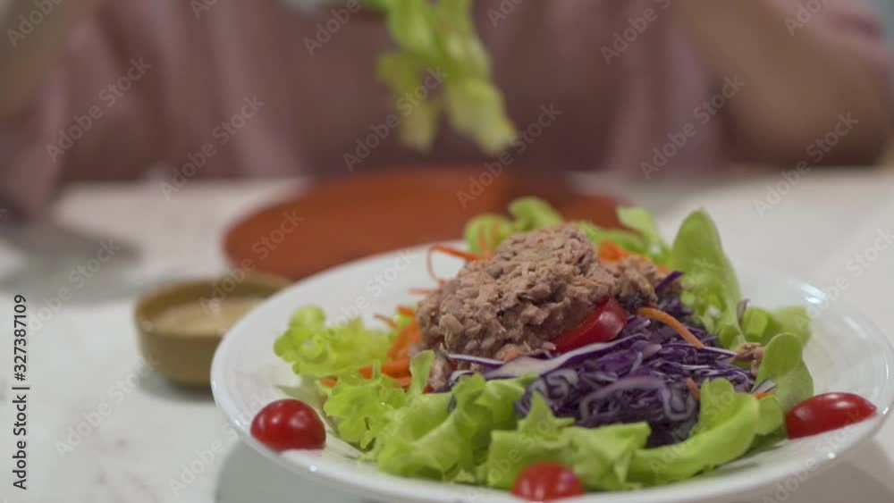 Dolly shot B roll. A beautiful woman in restaurant eating tuna salad in ...