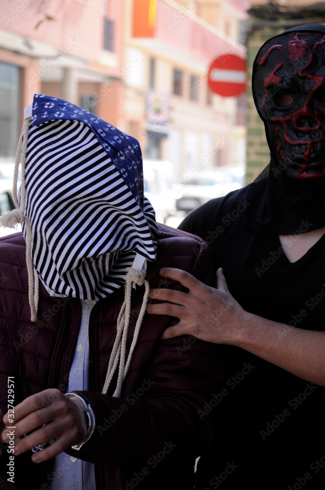 man wearing a mask kidnapping a man, putting a cloth bag covering the ...
