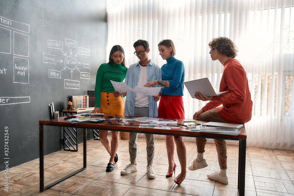 Creating new website. Creative group of four young designers discussing ...