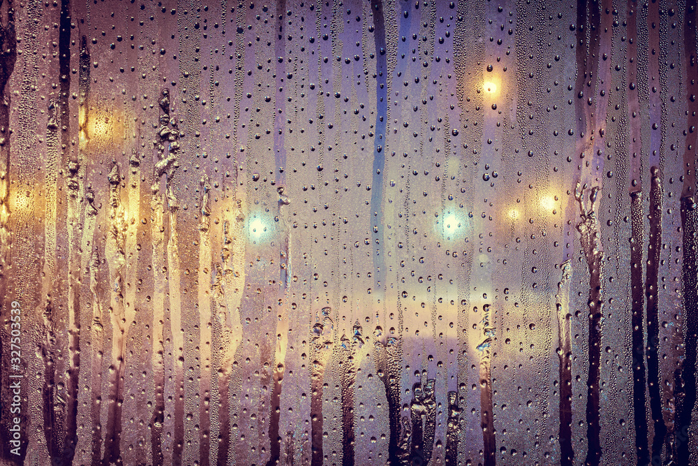 Window with drops of condensate late in the evening with street ...