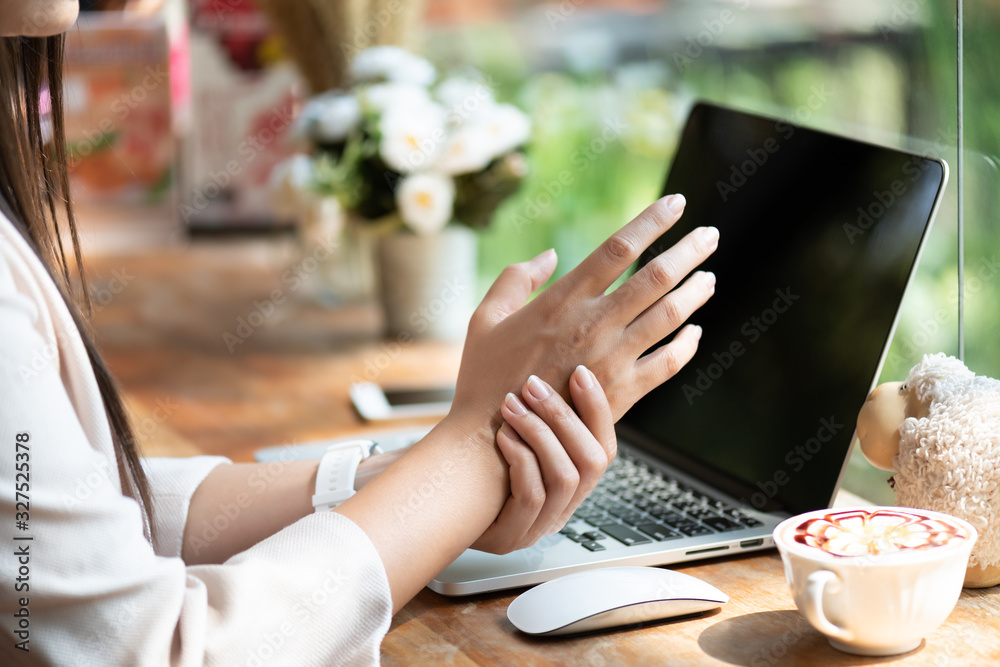 Closeup woman holding her wrist pain from using computer. Office ...
