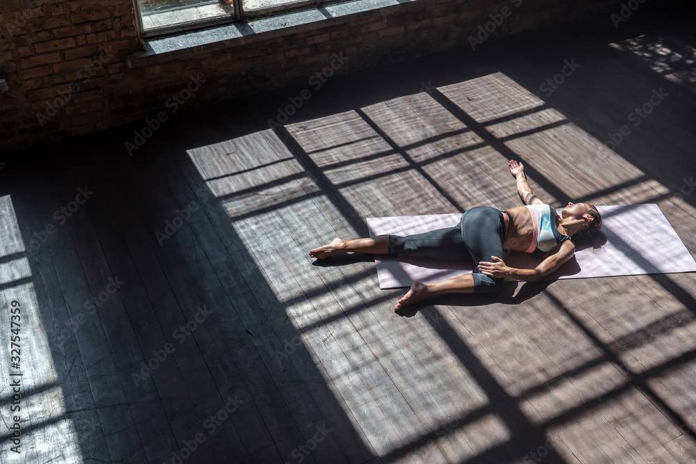 Top view young sporty fit woman practice hatha yoga instructor lie ...