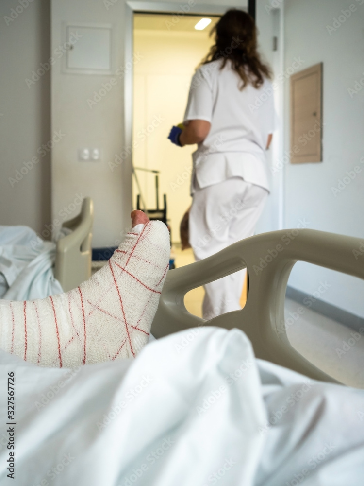 Man in hospital bed with broken leg attended by nurse. Stock Photo ...