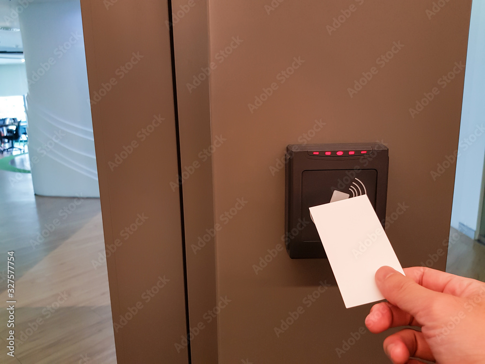 Men hand reaching to use RFID key card to access into office business ...