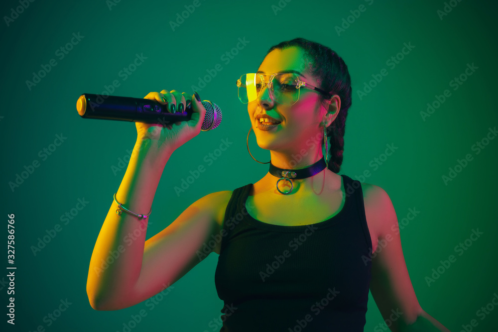 Caucasian female singer portrait isolated on green studio background in ...