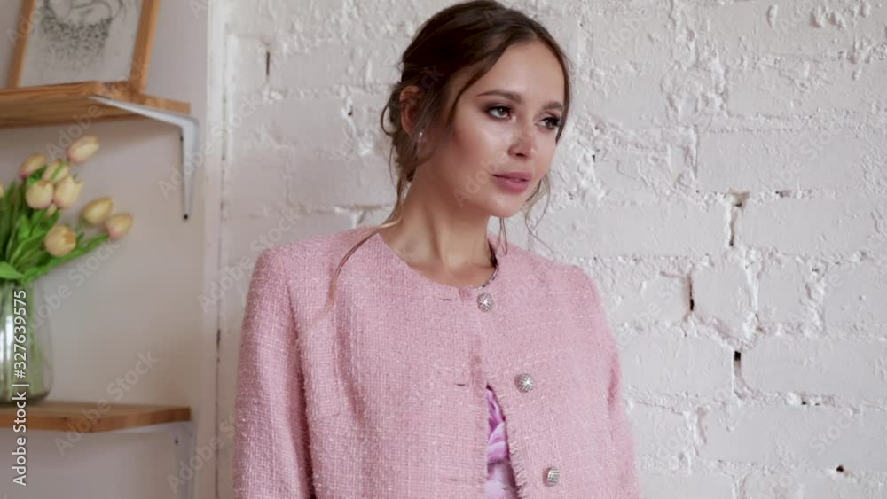 Professional model in blouse, leaning her back against the wall, posing ...